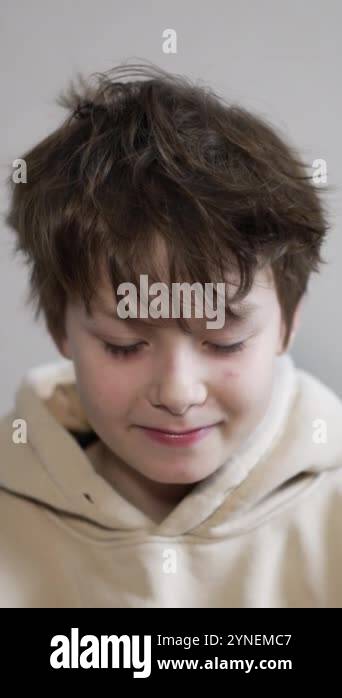 Handsome Caucasian boy posing in front of camera. Kid puts his hands on ...