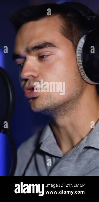 Singer recording a song in the studio. Male performer standing in front ...