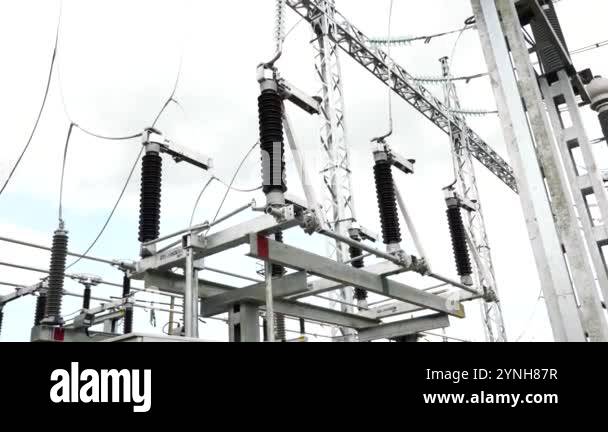 High voltage electrical substation. Power plant with high poles and voltage distribution cables ...