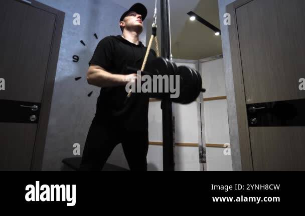 Pumping triceps of men's arms. Athlete in a home gym. A young athlete ...