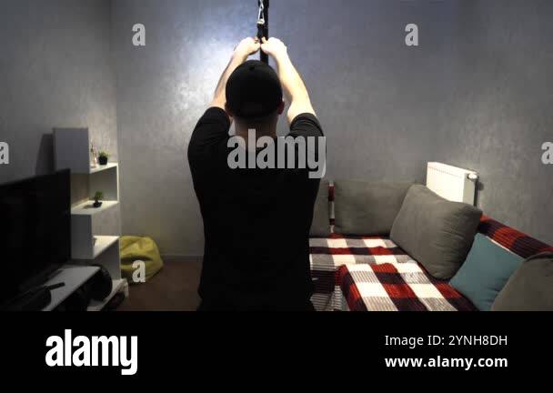 Pumping triceps of men's arms. Athlete in a home gym. A young athlete ...