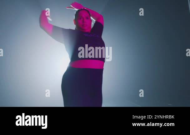 A dancer performing on stage with dramatic lighting. The background ...