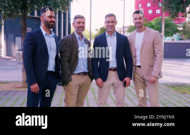 Four confident businessmen smiling and posing outdoors in an urban ...