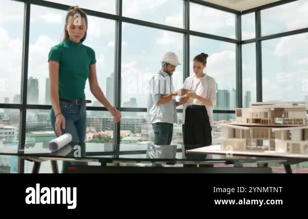 Engineer writing project plan while architect team discuss about house ...