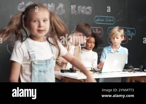 Girl smile and wave to camera while friend working or learning ...