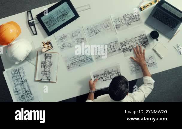 Top down aerial view of architect engineer placing building blueprint ...