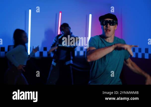 Skilled break dancer dancing in front of camera while diverse friend ...