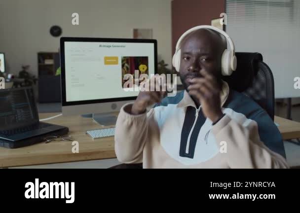 Medium portrait of cheerful African American IT engineer sitting at ...