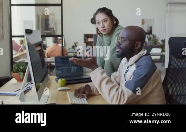 Medium side shot of young African American male programmer sitting at ...