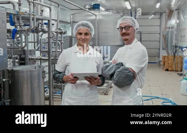 Medium arc portrait of two male and female Caucasian cheese making ...