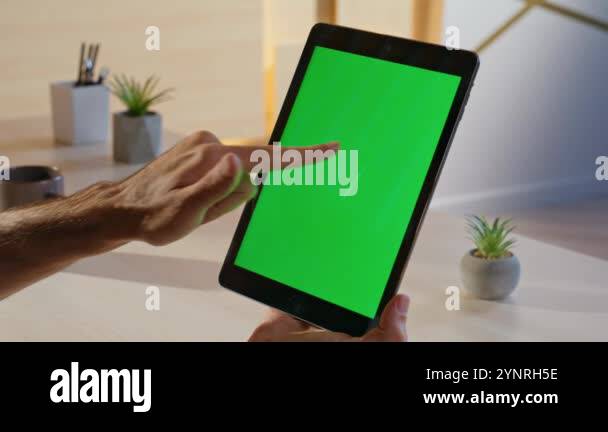 Employee working chromakey tablet at cozy workplace closeup. Businessman hands tapping green ...