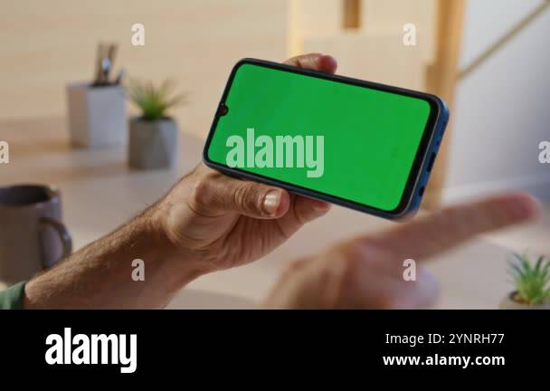 Office professional swiping chroma key smartphone in modern workplace ...