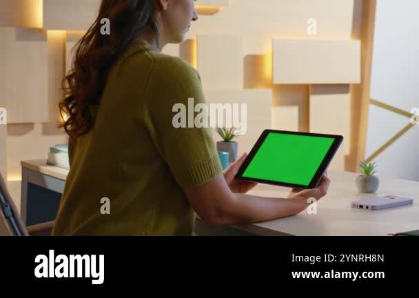 Employee watching webinar at chroma key tablet in modern workplace ...