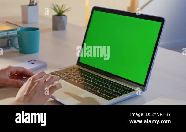 Fingers tapping touchpad green screen laptop at contemporary office ...