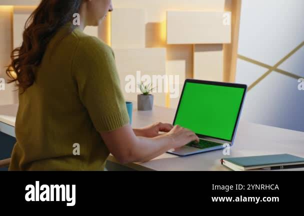 Girl secretary typing report at green screen laptop in company office ...