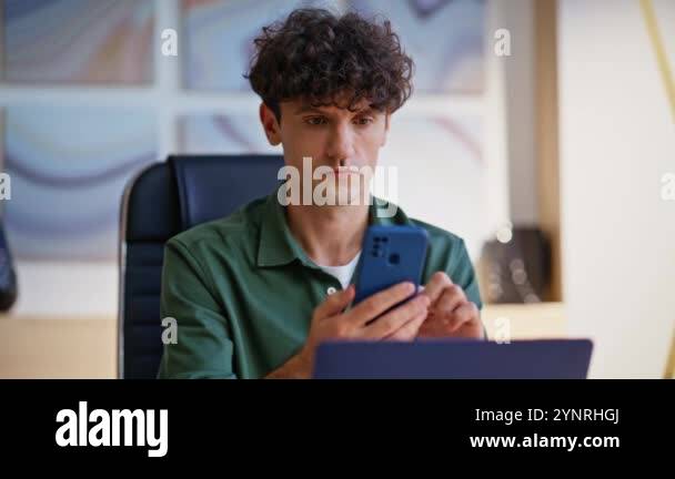 Confused manager looking mobile phone feeling frustrated by bad news ...