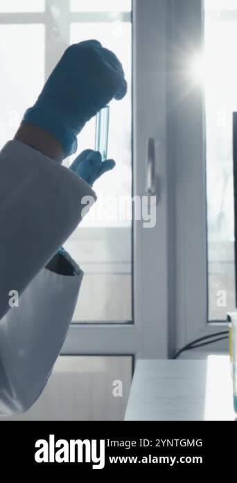 A dedicated scientist in a lab coat and PPE meticulously analyzes ...