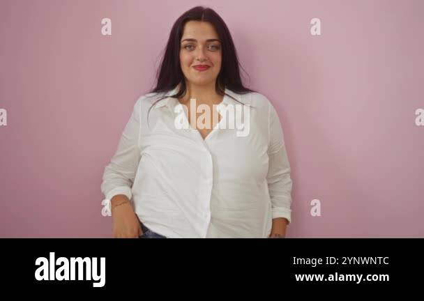 Young woman with a curvy physique posing confidently against an ...