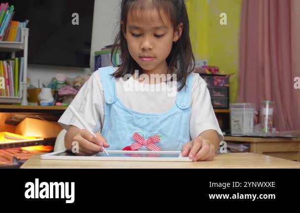 Cute happy asian girl touching digital tablet screen on table, using ...