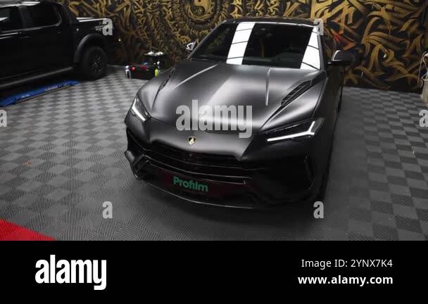 The video showcases a matte black Lamborghini Urus in a showroom ...