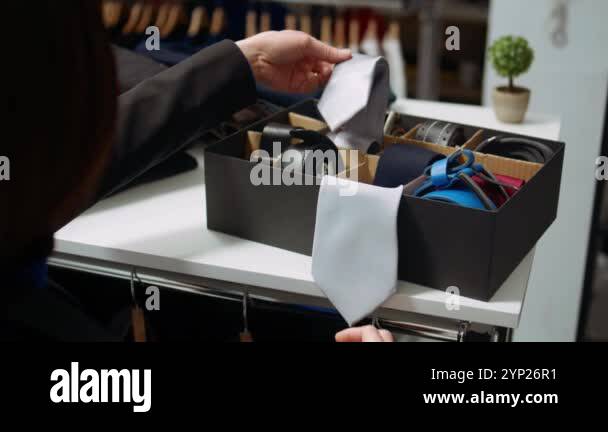 Asian retail assistant displaying colorful chic accessories in the ...