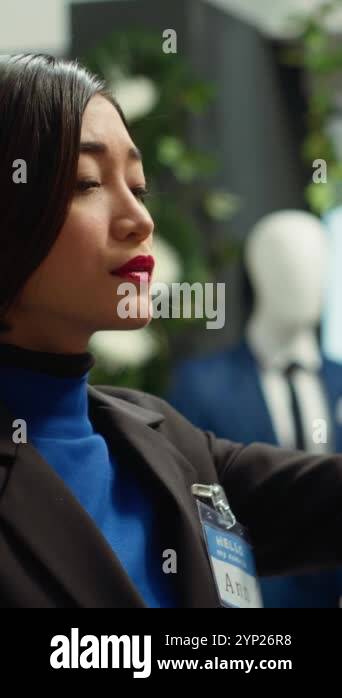 Vertical Video Asian retail assistant displaying colorful chic ...