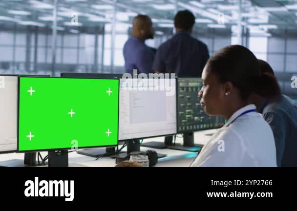 Software developer in server farm ensuring data remains shielded from potential threats using ...