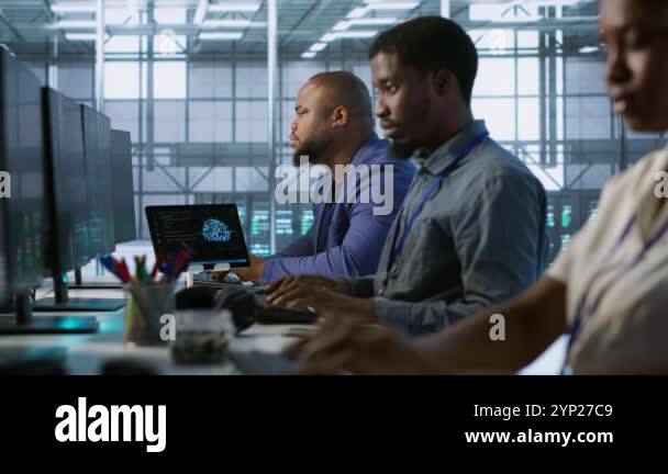 Cheerful server room workers laughing together in office while ensuring ...