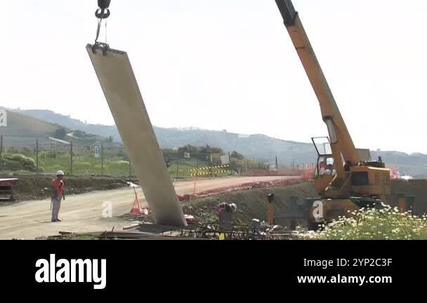 Boom crane moving up a big panel to assembly in a industrial warehouse ...