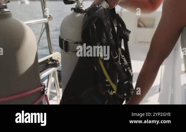 A close-up shot features scuba diving gear secured on a tank aboard a ...