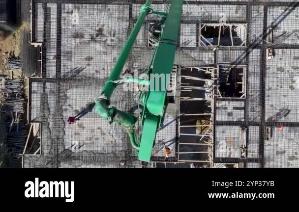 See workers bending rebar and laying concrete for the foundation of a ...