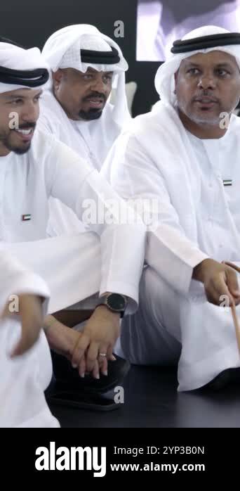 Dubai, UAE - June 2024: A vibrant group of men dressed in traditional ...