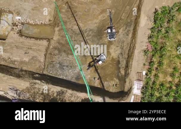 Witness the start of construction with concrete being poured into the pit to form a high-rise ...