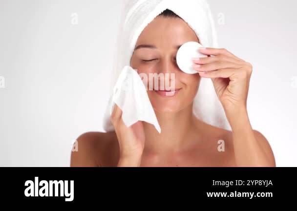 A smiling woman with a towel wrapped around her head playfully uses a ...