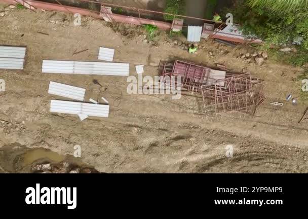 Fly over a busy construction site where machinery and workers ...