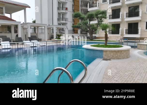 Fly over an exclusive pool in a high-end complex, showcasing its luxury ...