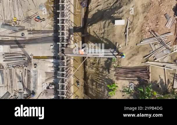 Observe the construction workers building load-bearing walls and floors ...