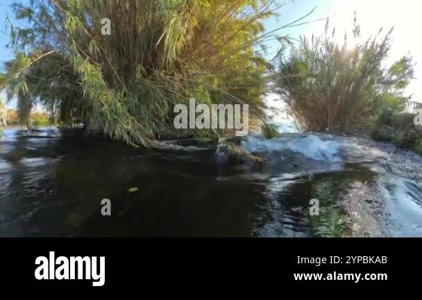 Slow-motion view as the camera slowly moves along a fast-flowing river ...