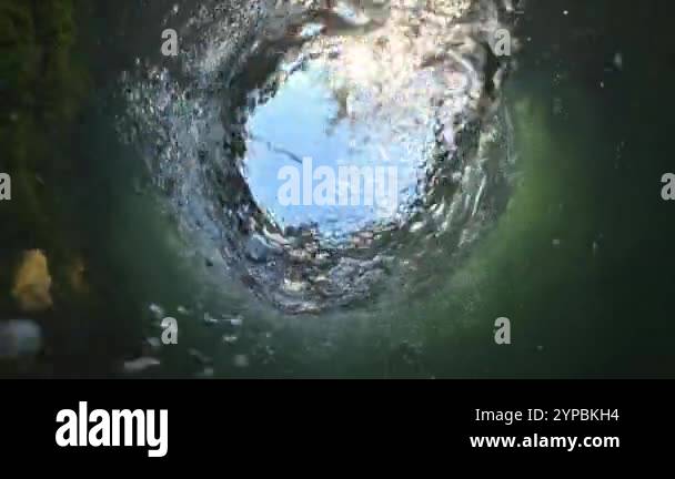 Close-up underwater shot of a circular vortex of bubbles, with sunlight ...