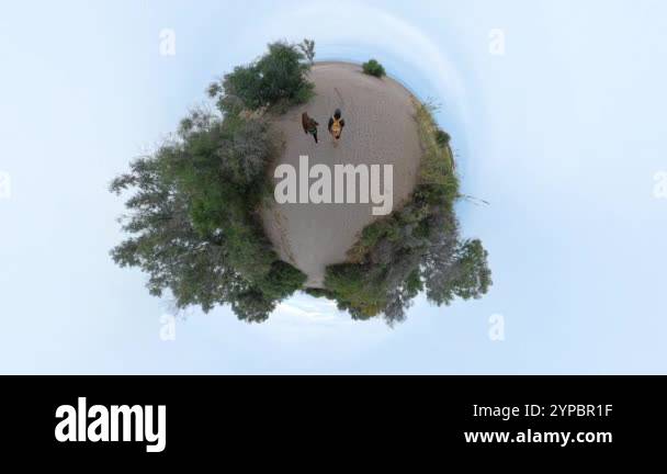 The camera creates a Tiny Planet effect, wrapping the sandy path, trees ...