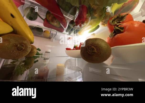 A rotating camera inside a refrigerator captures a man opening the door ...