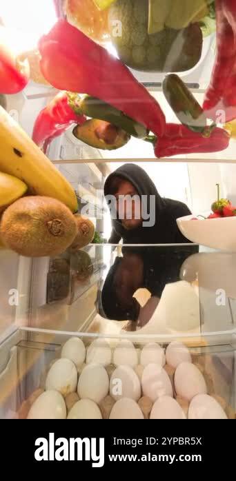 Vertical video. Zoom, A perspective from inside a refrigerator captures ...