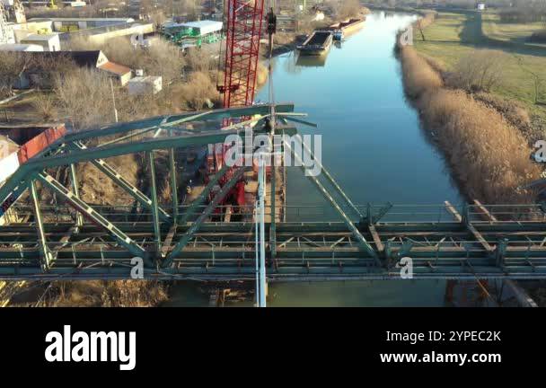 Above dolly move around view workers are cutting old railroad bridge ...