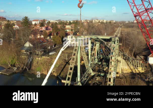 Above dolly move around view workers are cutting old railroad bridge ...