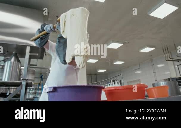 Medium shot of young Caucasian male cheese factory worker in white ...