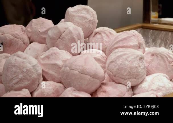Close-up of pink zephyr dusted with powdered sugar. Sweet treat ...