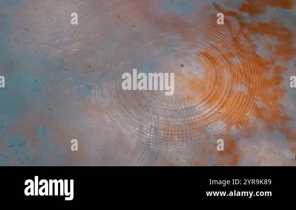 Raindrops make ripples on a water surface with orange sediment. Ideal ...