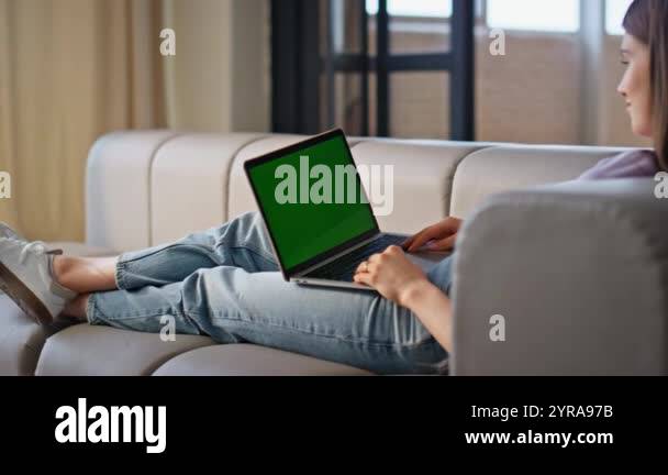 Lady browsing mockup laptop lying home sofa closeup. Young woman ...