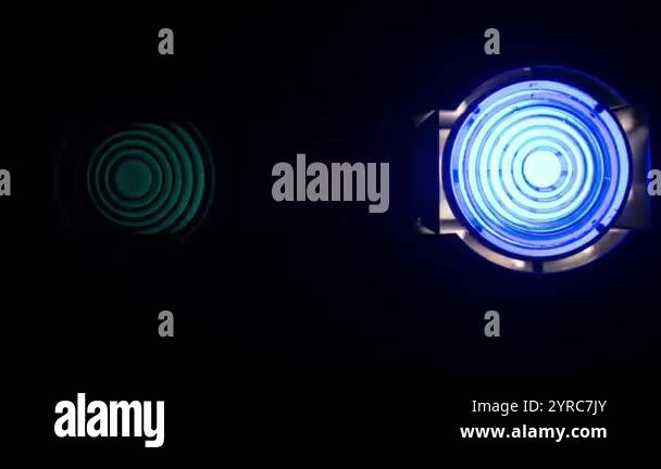 Three RGB lights with Fresnel lenses flash in sequence against a black ...