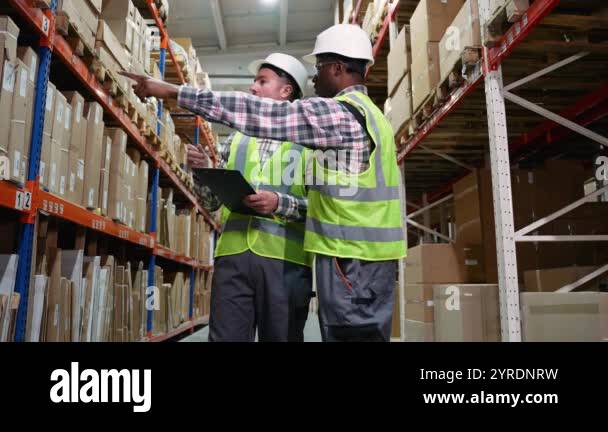 Two warehouse workers collaborate on inventory inspection, ensuring ... Two warehouse workers collaborate on inventory inspection, ensuring ...
